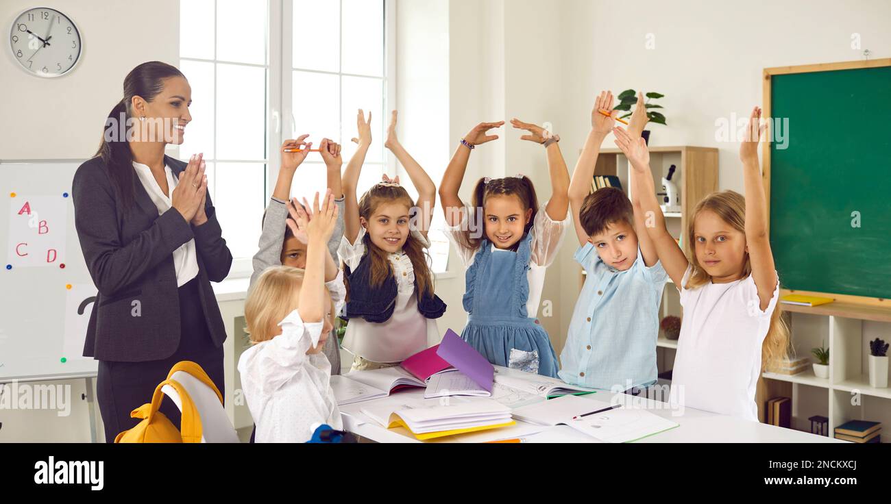 Happy school teacher and her elementary students playing and having fun ...