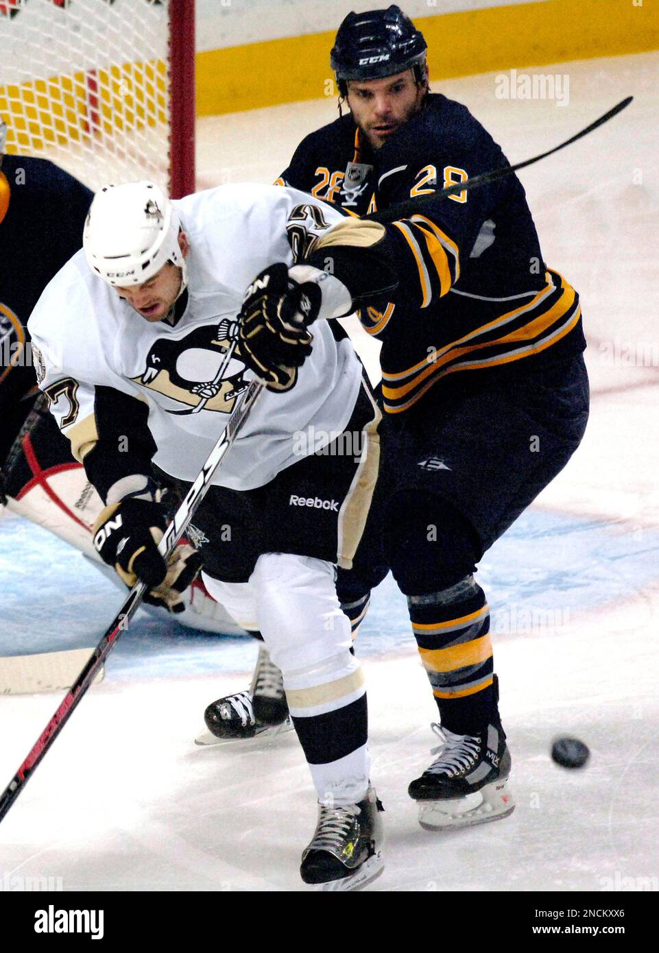 Pittsburgh Penguins right winger Craig Adams, left, is checked by ...