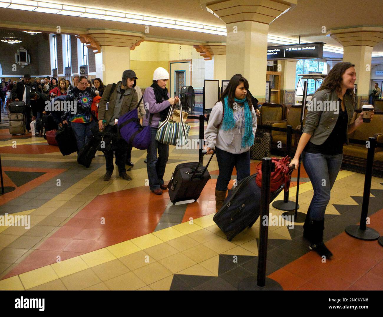 Passengers line up to board an Amtrak train early morning on Wednesday ...