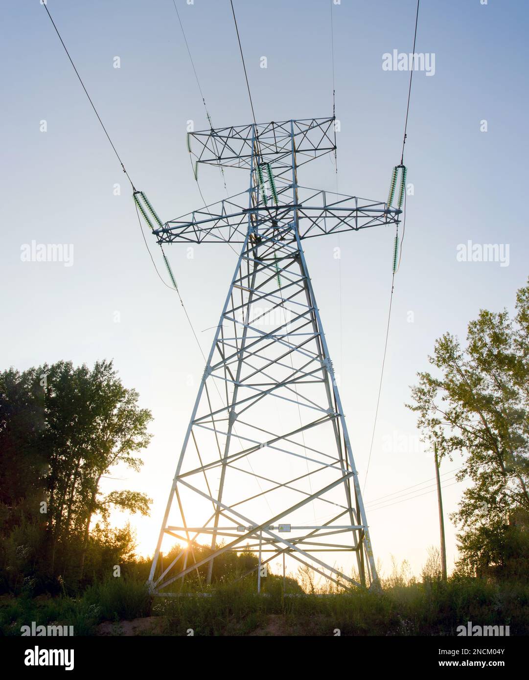 Anchor a large tower backbone transmission line is at sunset in a field ...