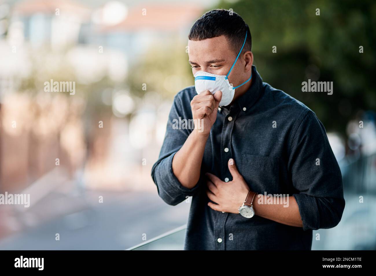 Could a cough mean its Covid. a young man coughing and wearing a mask ...