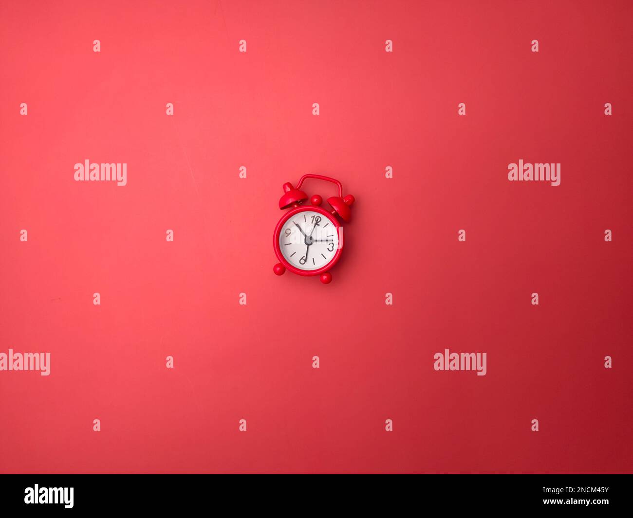 A top view of a red alarm clock on a red background Stock Photo - Alamy
