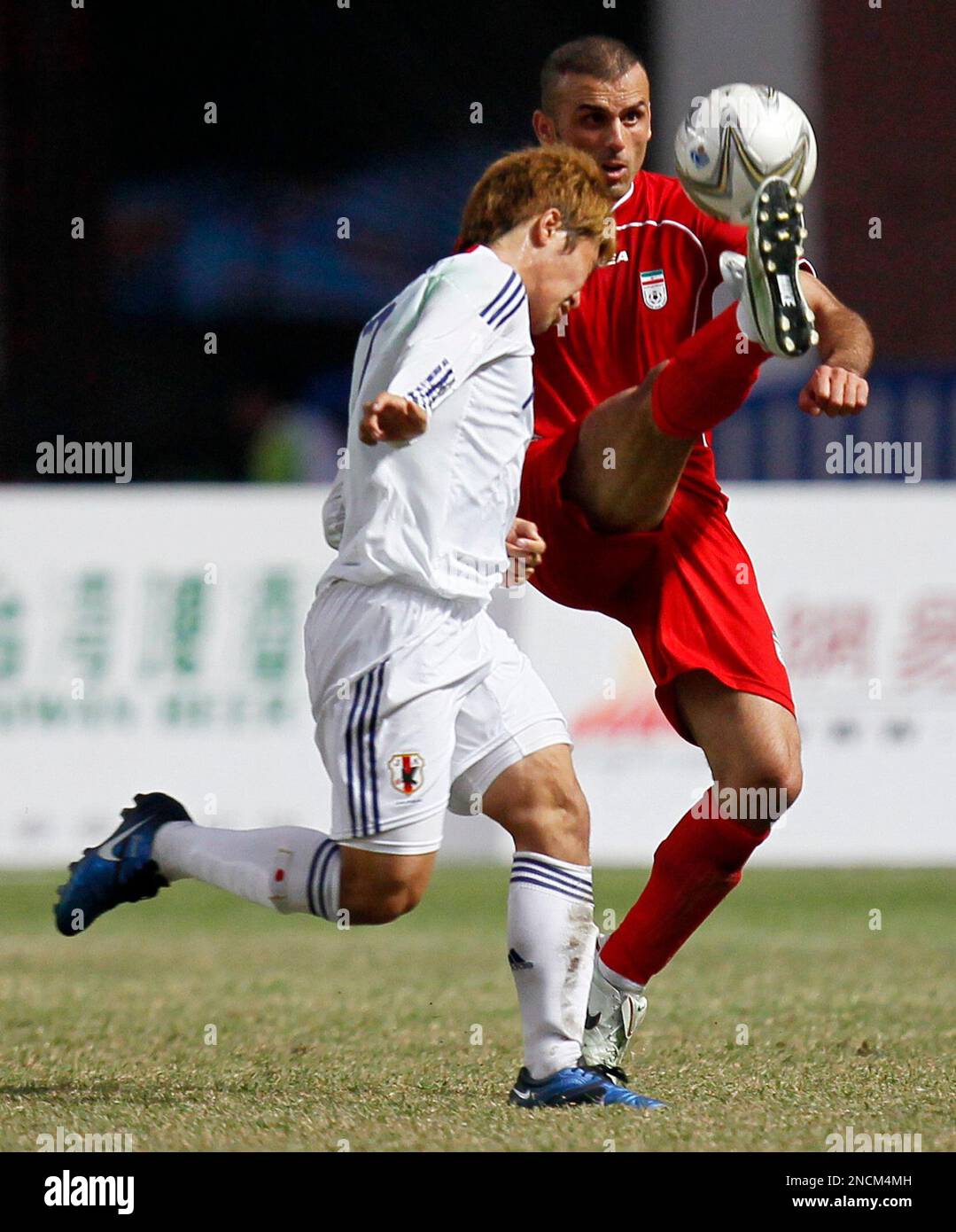japan's Ryohei Yamazaki, left, attempts to head the ball as Iran's ...