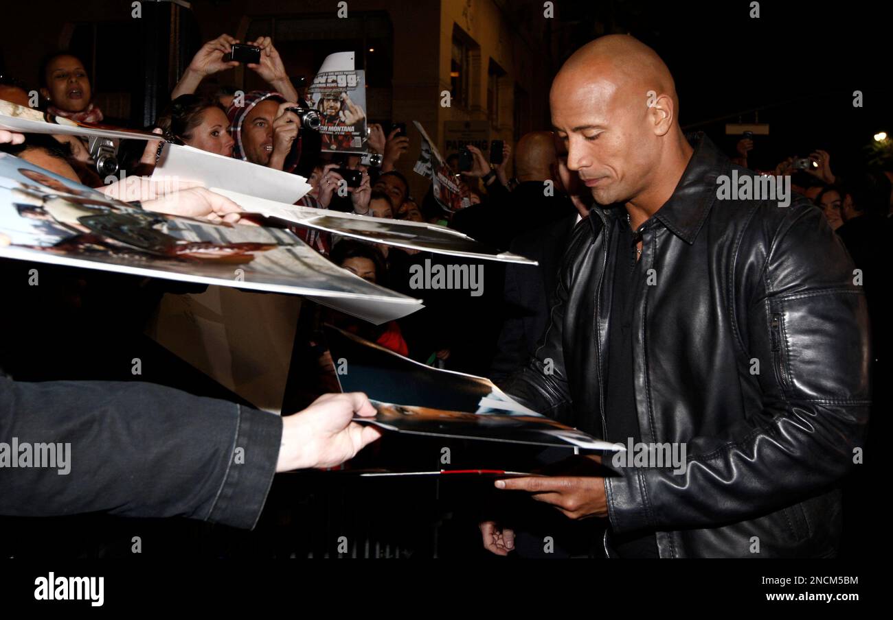 Cast member Dwayne Johnson signs autographs for fans at the premiere of ...