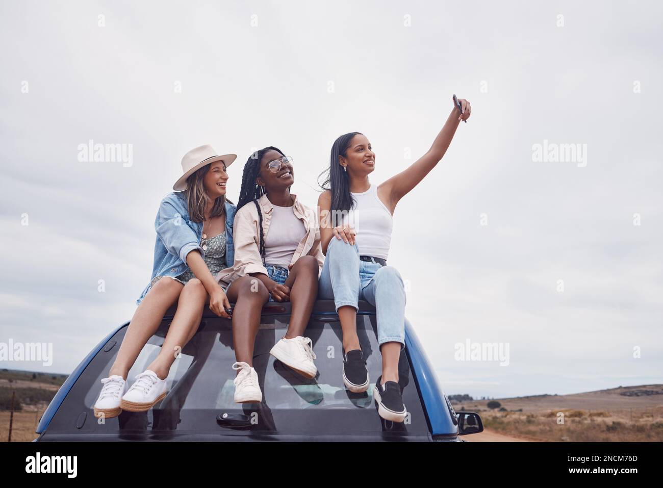 Road trip selfie of women friends on car roof with sky mockup for ...