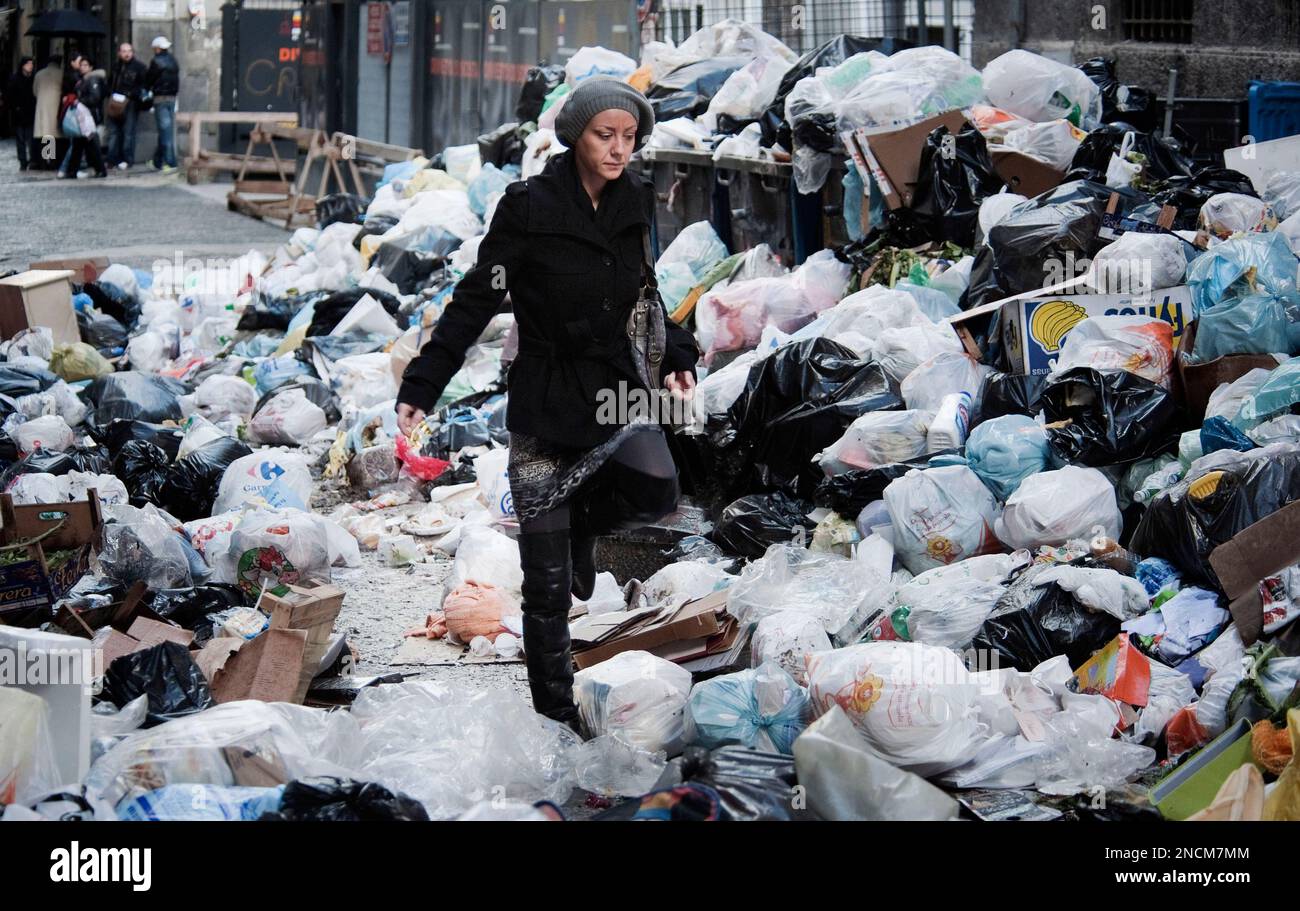 A woman makes her way through uncollected trash in Naples Italy, Monday ...