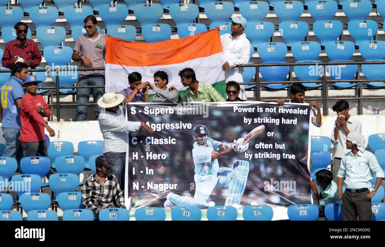 Cricket enthusiasts display a poster of Indian cricketer Sachin ...