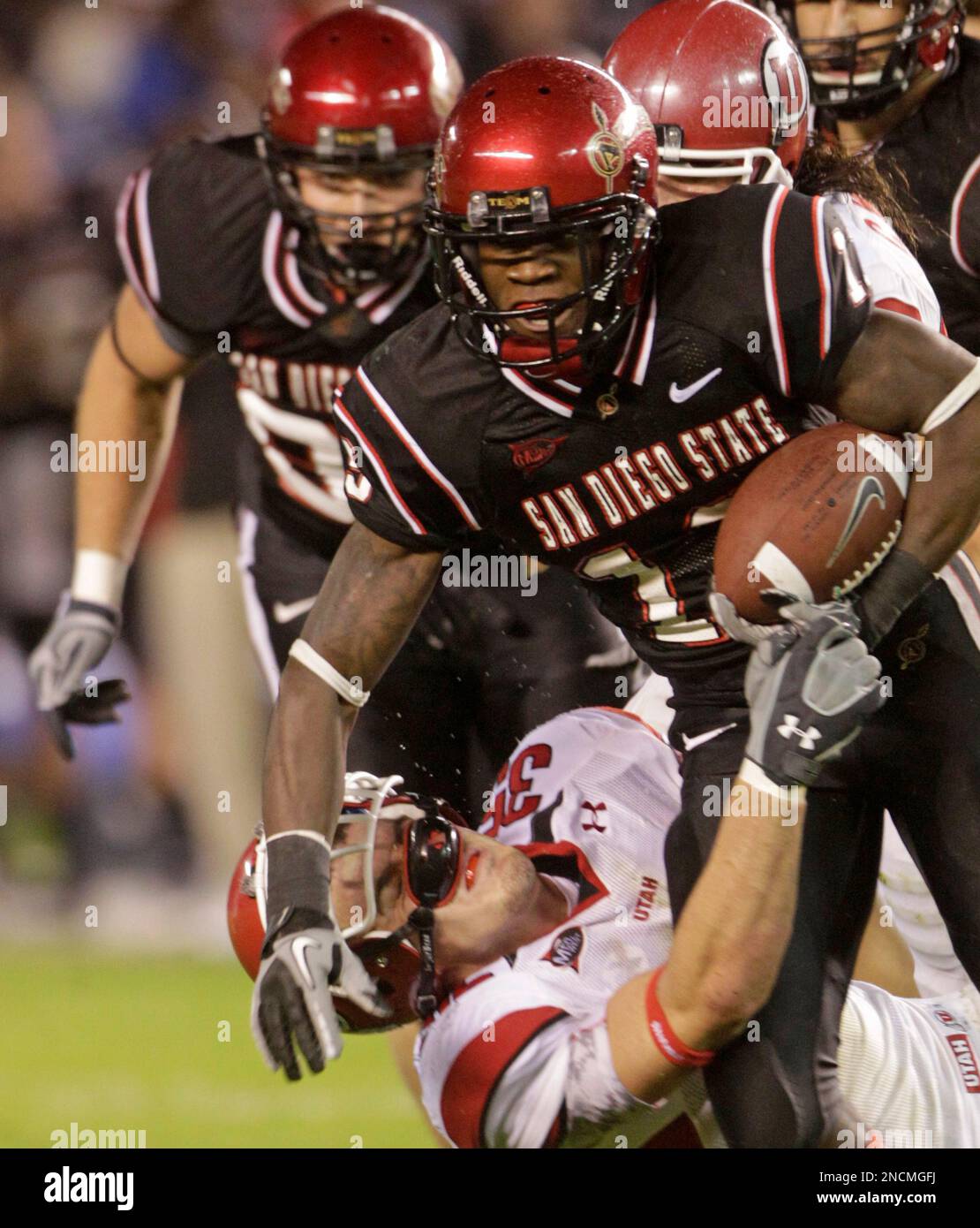 San Diego State's Ronnie Hillman drives through Utah's Greg Bird while ...