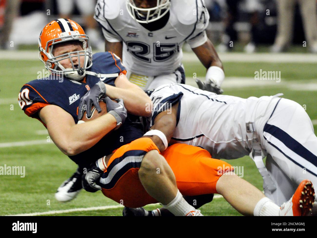 Syracuse's Nick Provo, left, is tackled by Connecticut's Jerome Junior ...