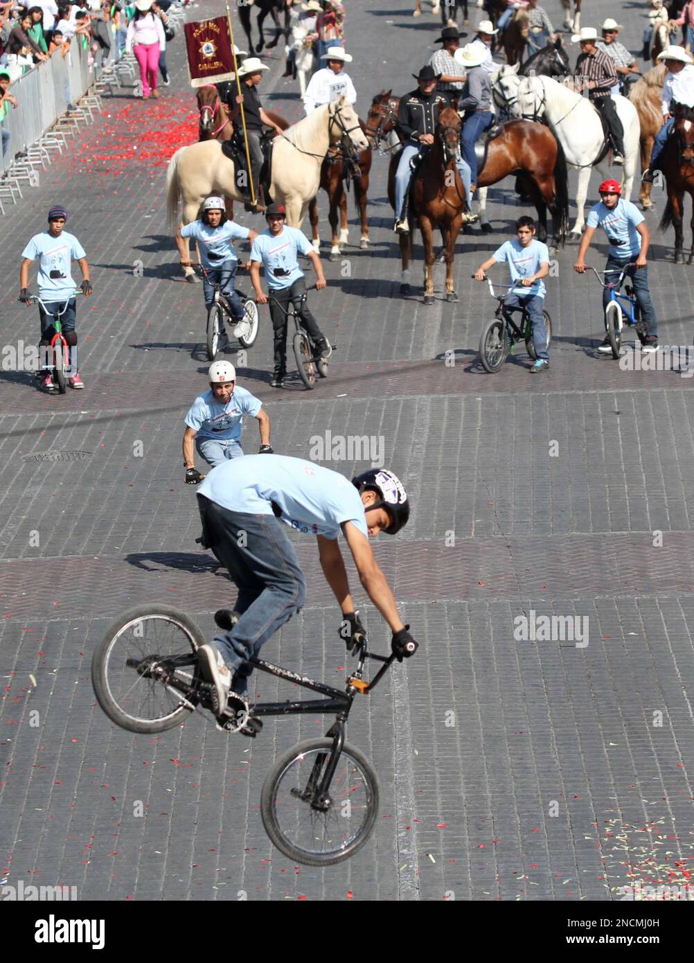 A student performs on his bike during a parade marking the centennial ...