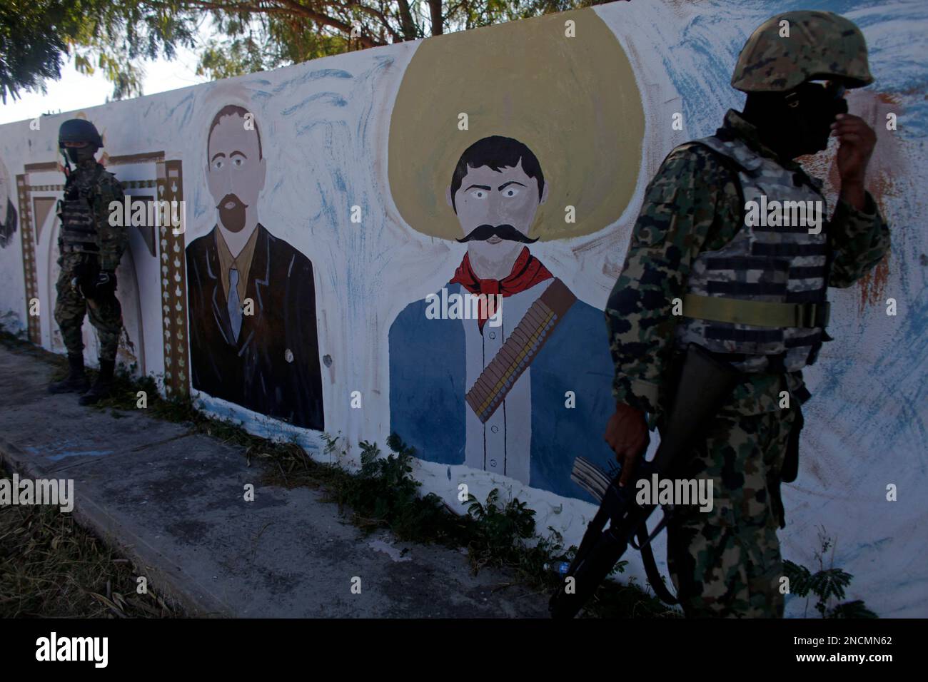 Navy marines stand next to a wall painted with portraits of Mexican ...