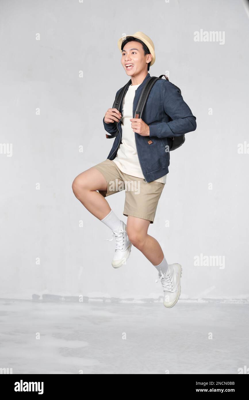 Happy young traveling man jumping isolated on white Stock Photo - Alamy