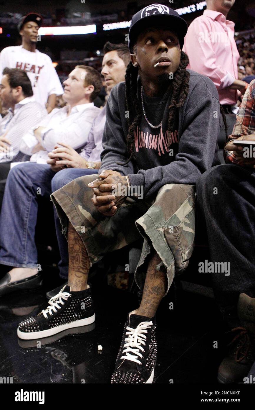 Rapper Lil Wayne watches an NBA basketball game between the Miami Heat ...