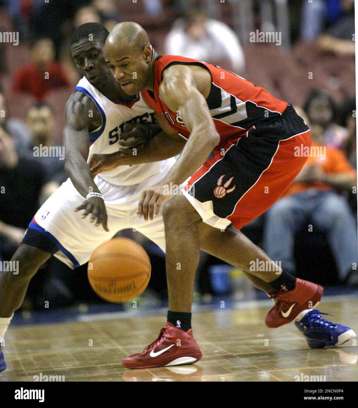 Philadelphia 76ers' Jrue Holiday, left and Tronto Raptors' Jarrett Jack ...