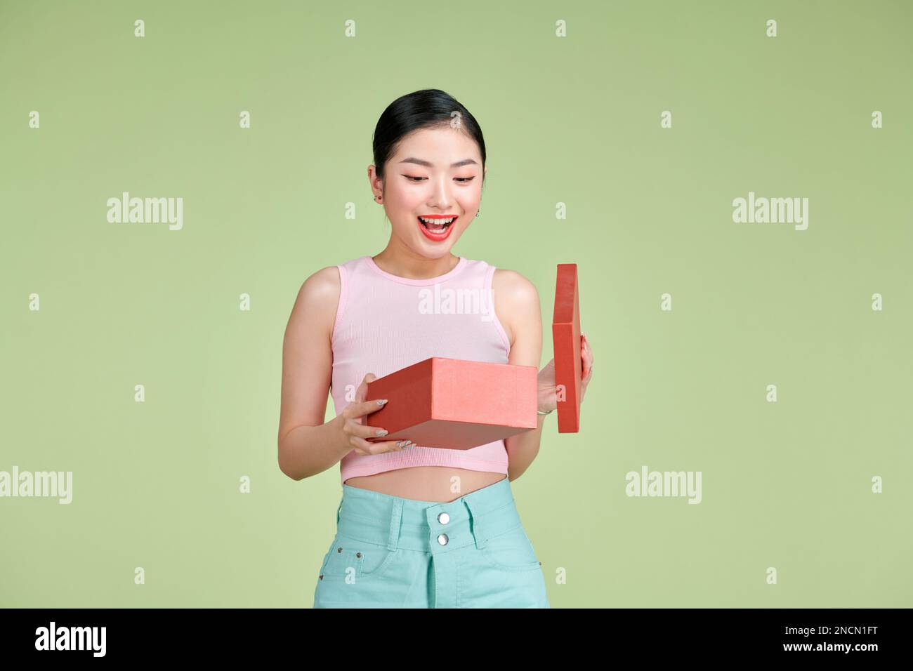 Emotional brunette young woman opens gift box, having overjoyed ...