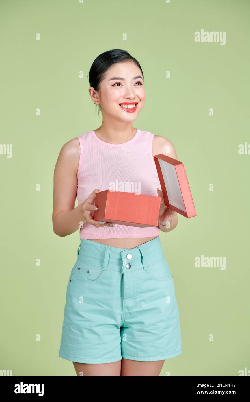 Emotional brunette young woman opens gift box, having overjoyed ...