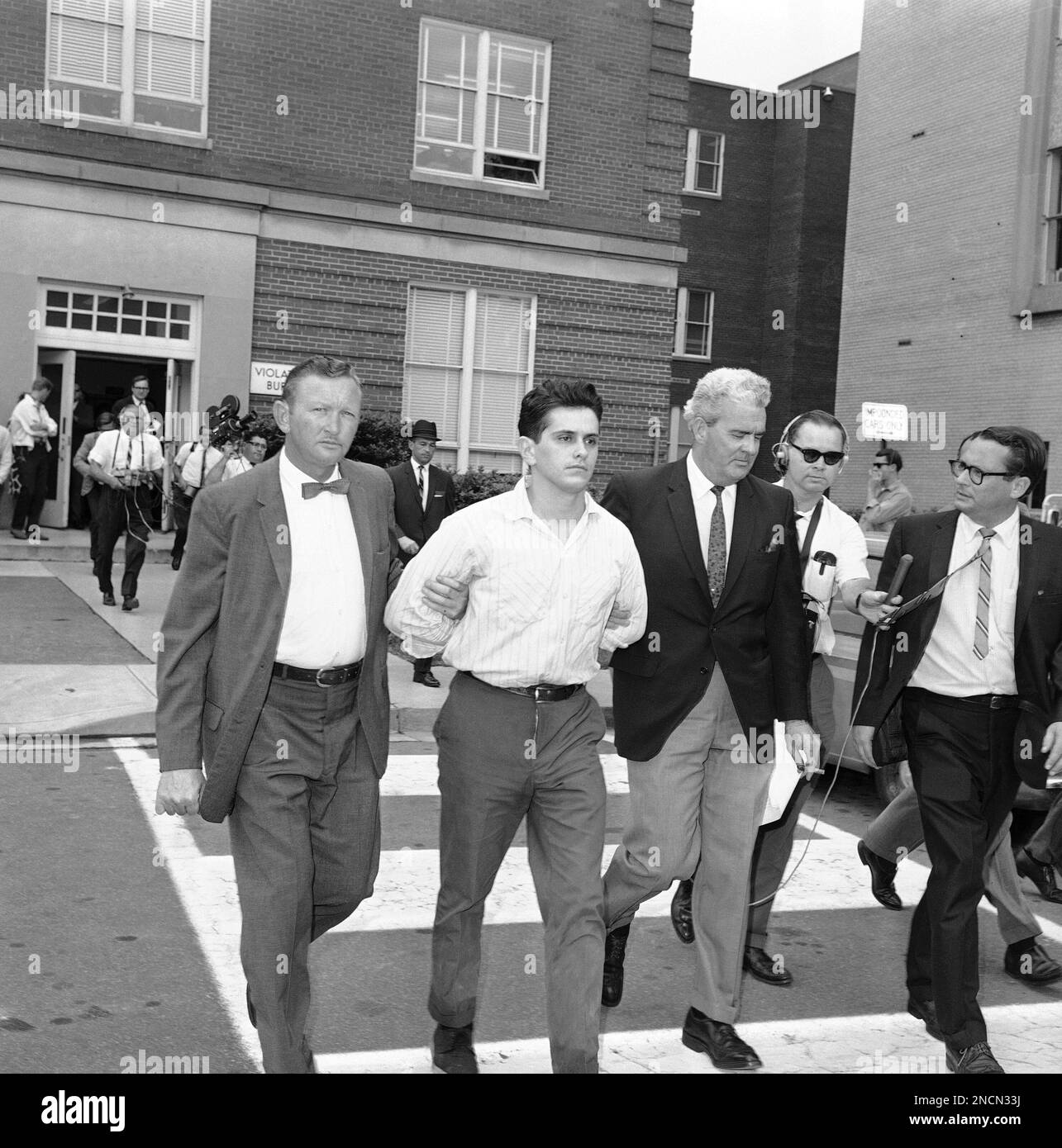 John Patler, 29, of Arlington, Va., is lead by police outside Arlington ...