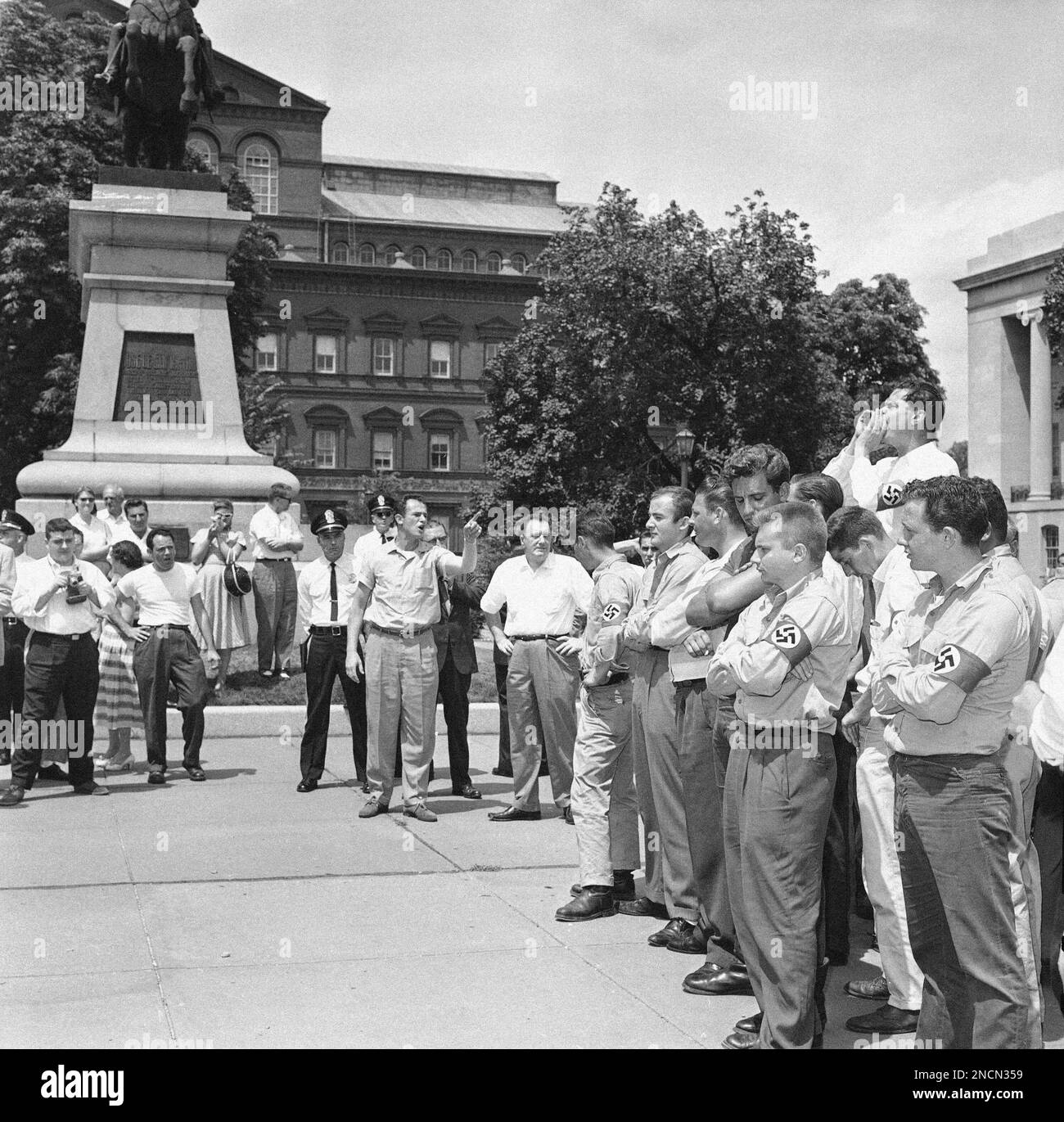 Surrounded by Swastika-wearing members of his American Nazi Party ...