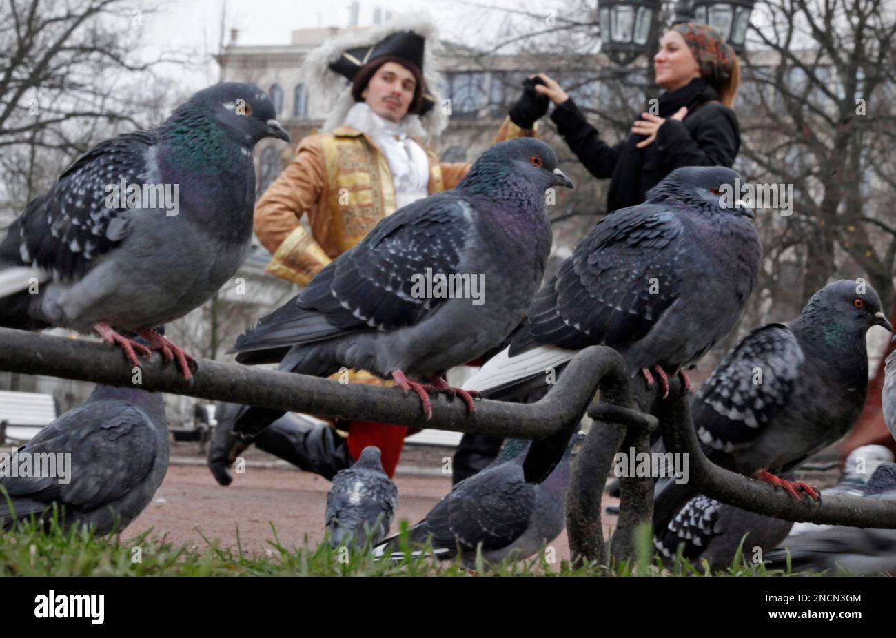 A woman poses with a street actor dressed in 18th century suit as ...
