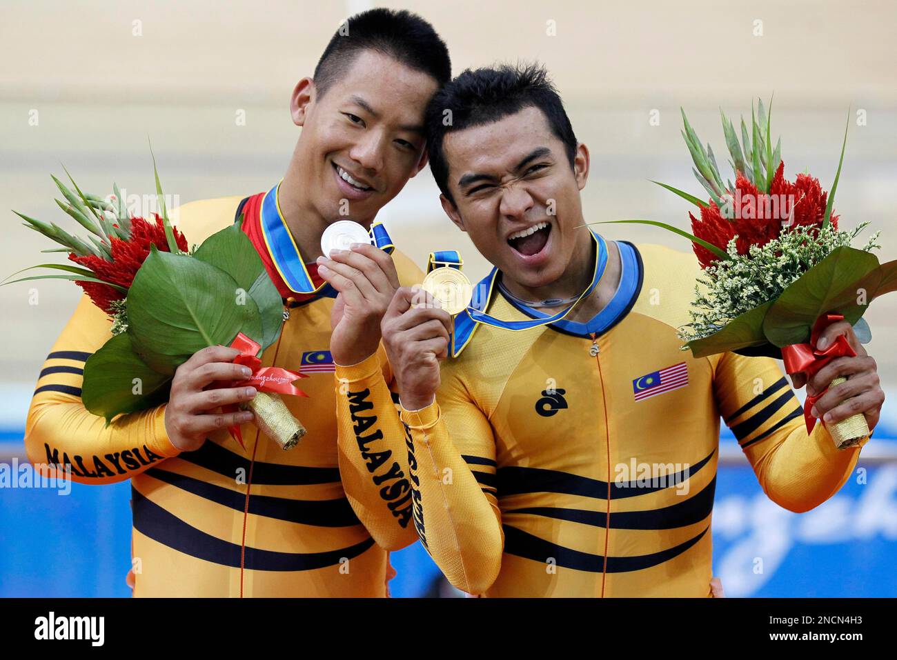 Malaysia's Josiah Ng, left, holds hi silver medal with compatyriot and ...