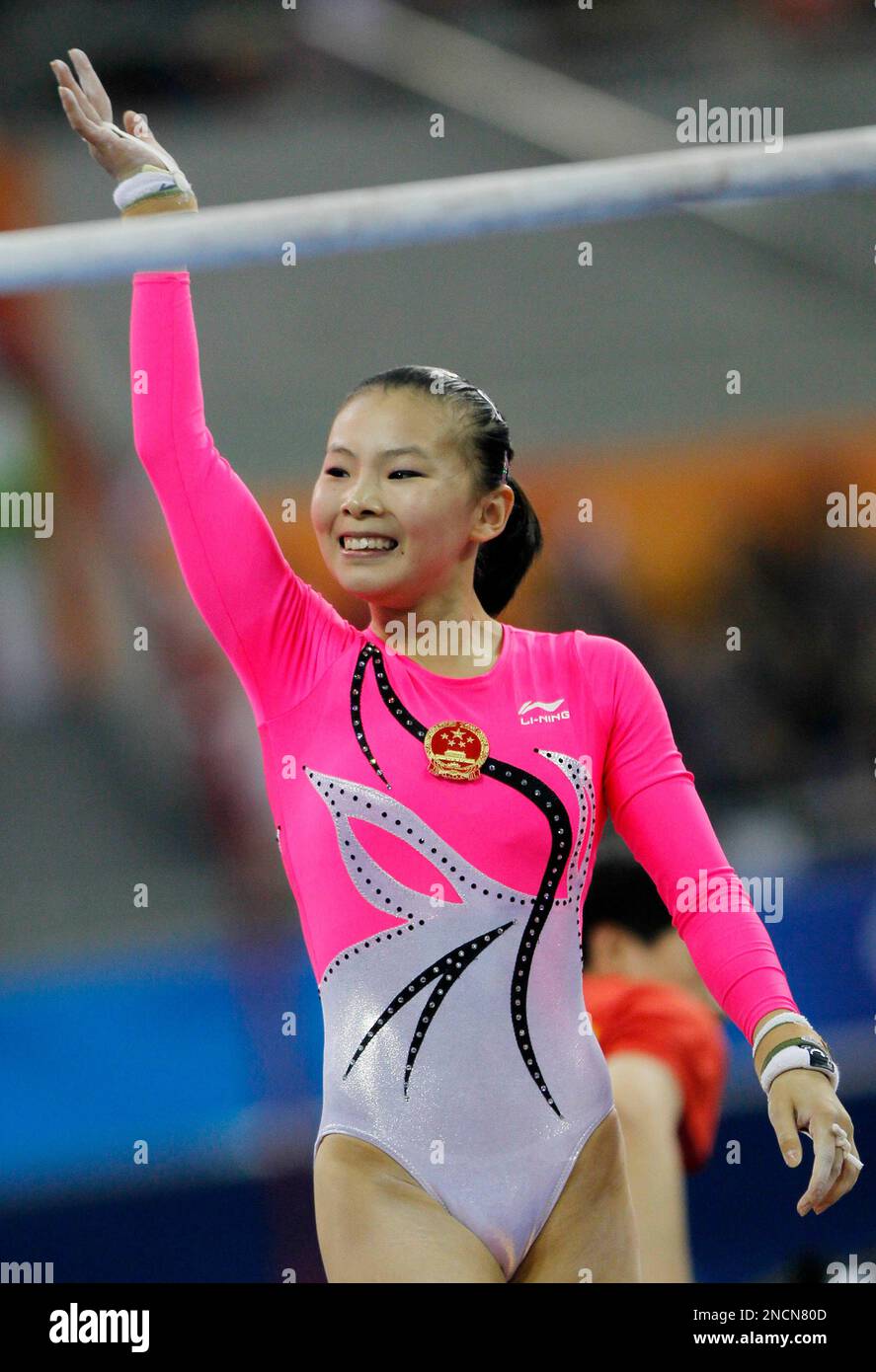 China's gold medal gymnast He Kexin waves after her performance on the women's uneven bars at ...