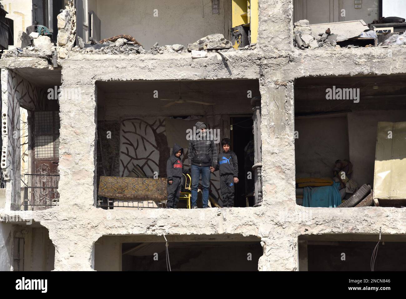 Saleppo, Syria. 13th Feb, 2023. Ali Abdul-Rahman and his two kids stand ...