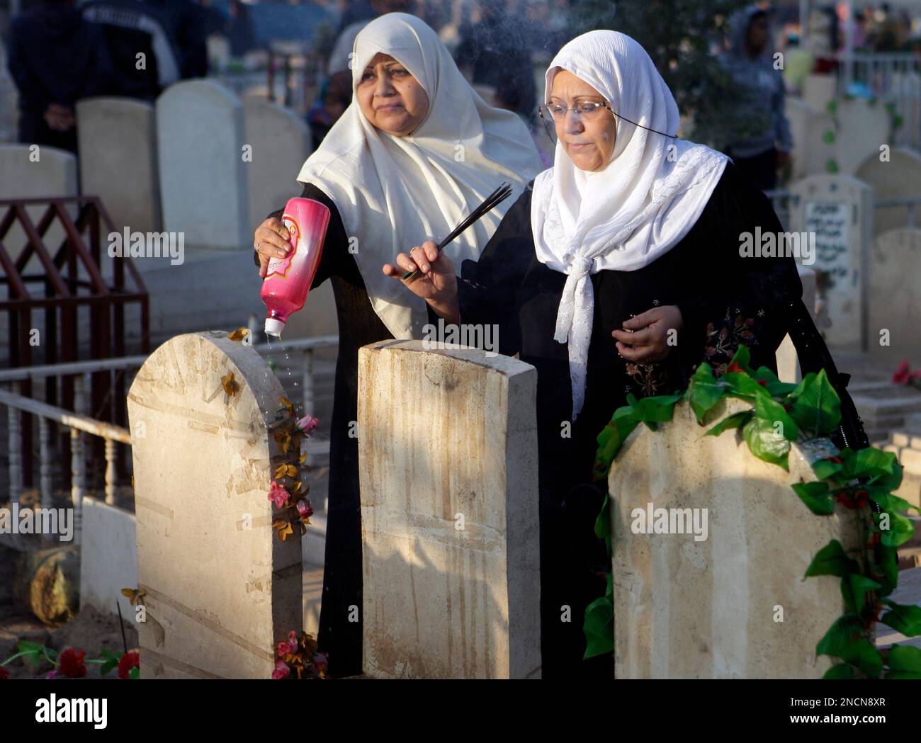 Iraqi Sunni Muslim women sprinkle rose water and burn incense over the ...