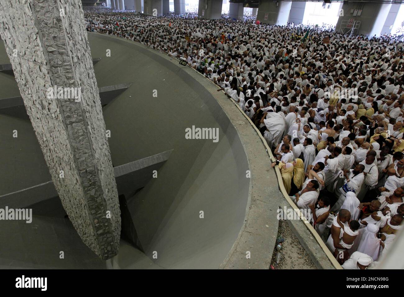Muslim pilgrims cast stones at a pillar, symbolizing the stoning of ...
