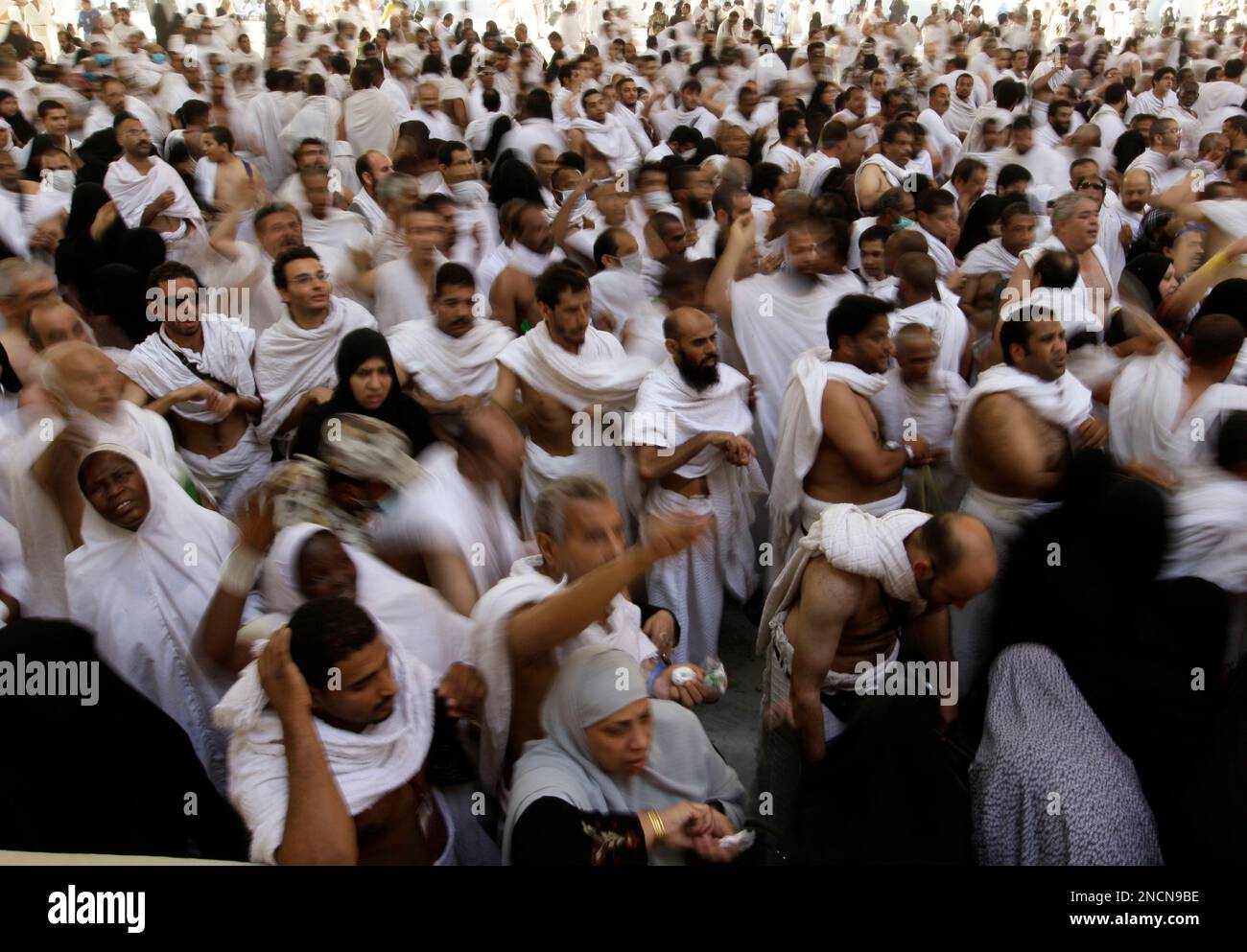 Muslim pilgrims cast stones at a pillar, symbolizing the stoning of ...