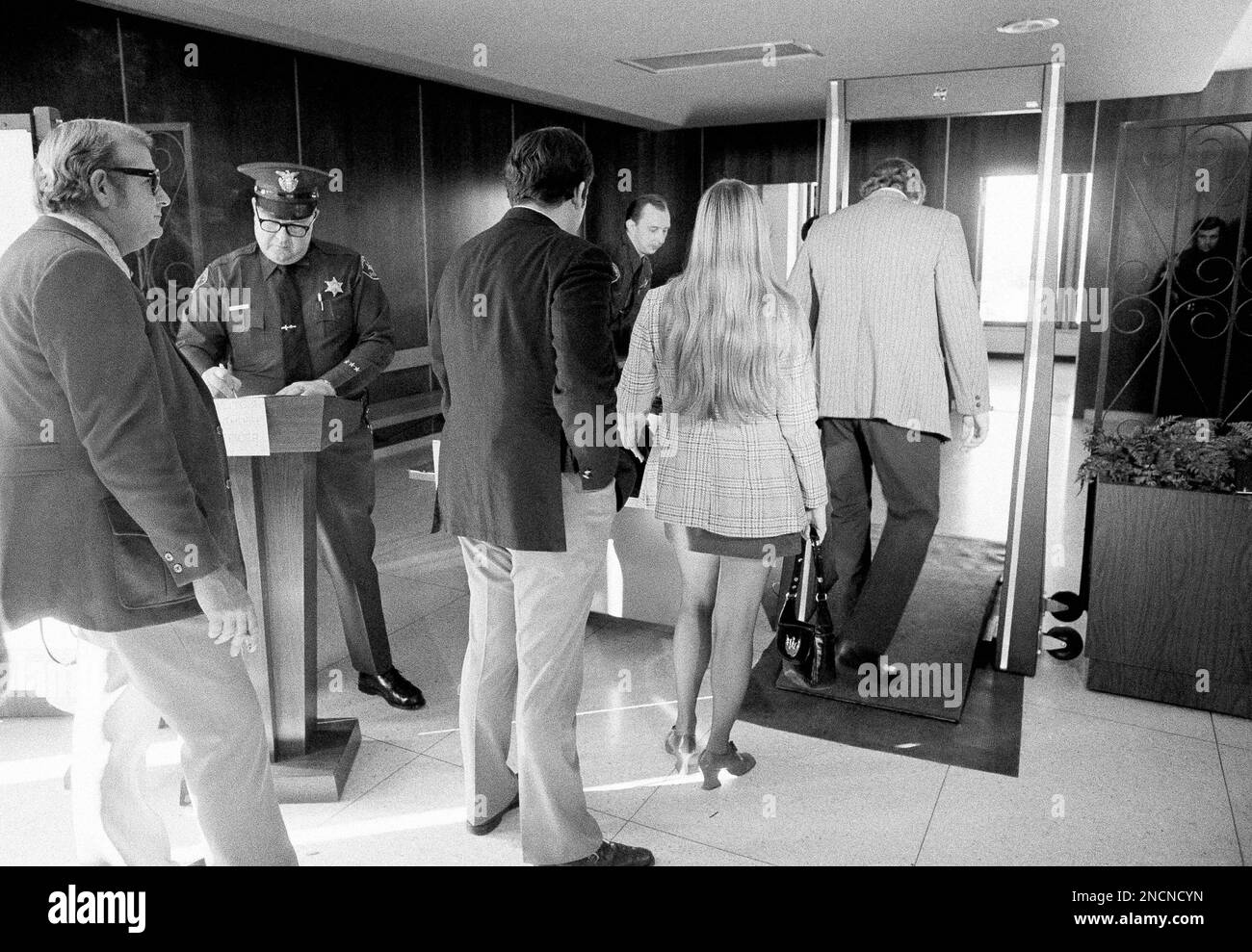 Spectators and newsmen are registered and checked by metal detector as ...
