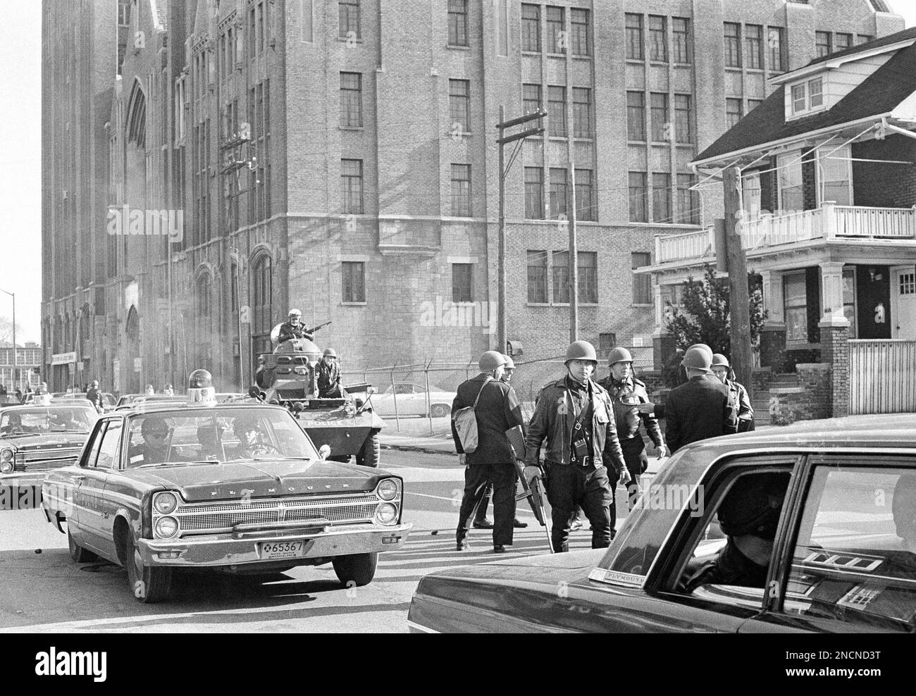 A Detroit police armored vehicle in a phalanx of squad cars starts off ...