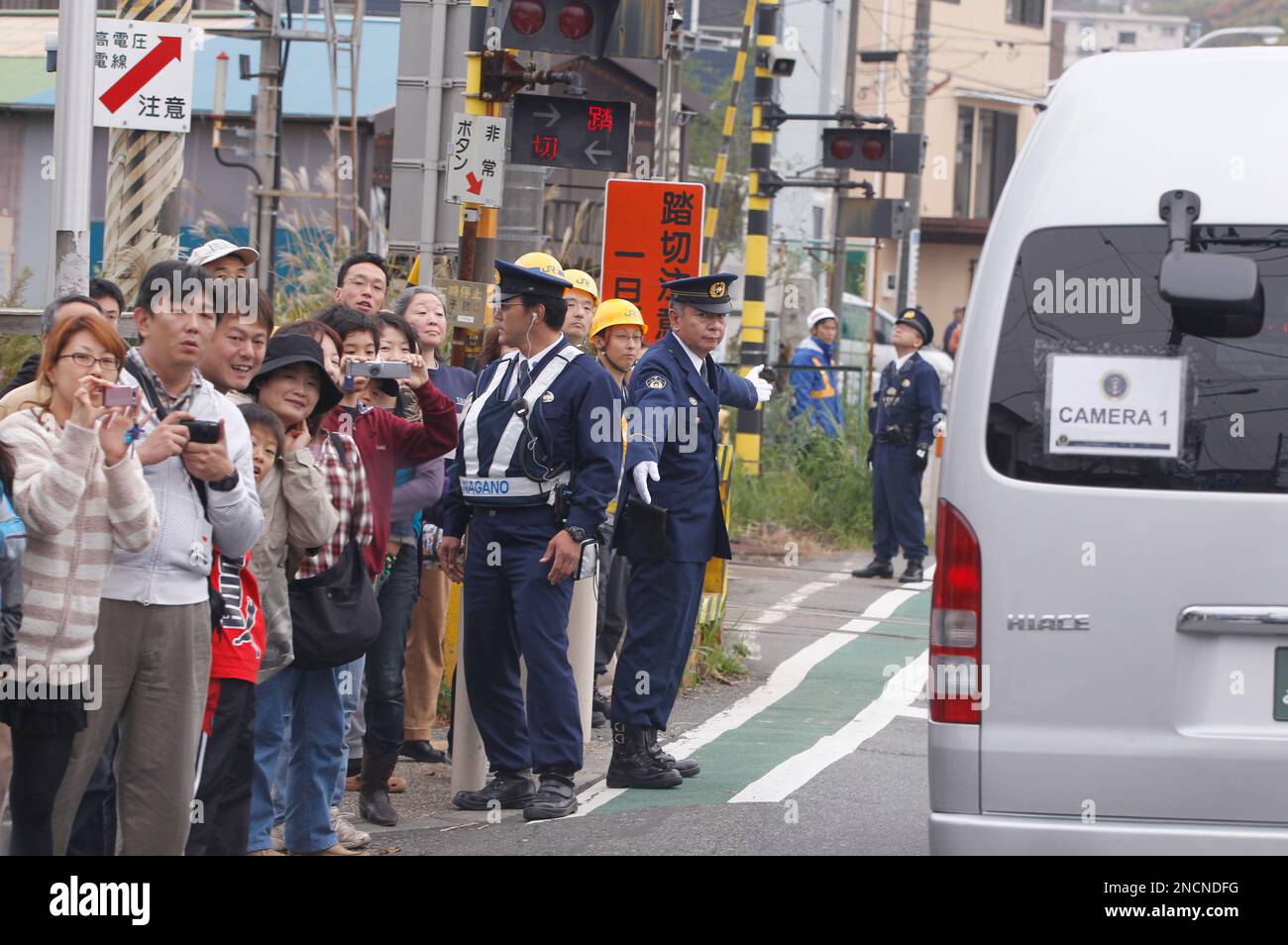 Onlookers watch as the motorcade of President Barack Obama drives past as he visits the Great ...