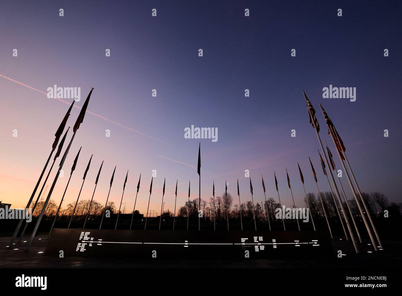 The sun rises over the flags of the countries of NATO outside the ...