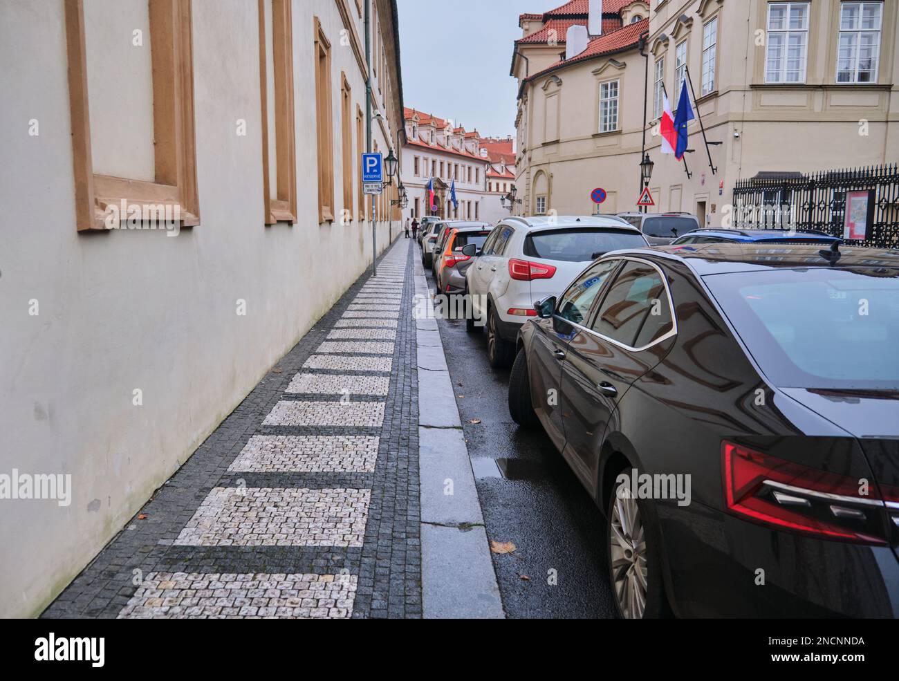 Parked cars on street in line on side walk by pavement Stock Photo - Alamy