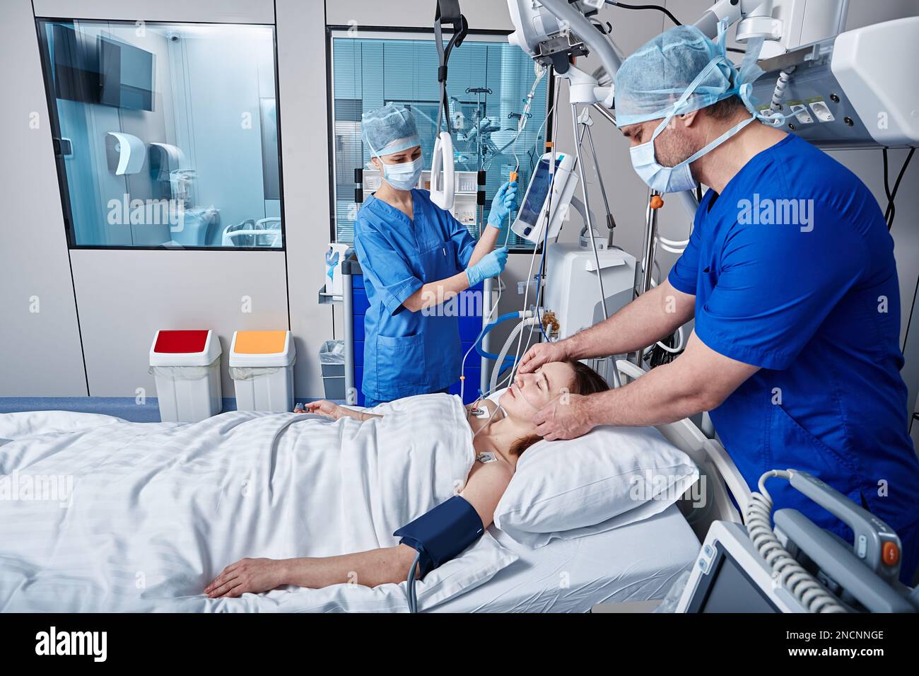 Intensive care patient. Nurses attending to female patient in intensive ...