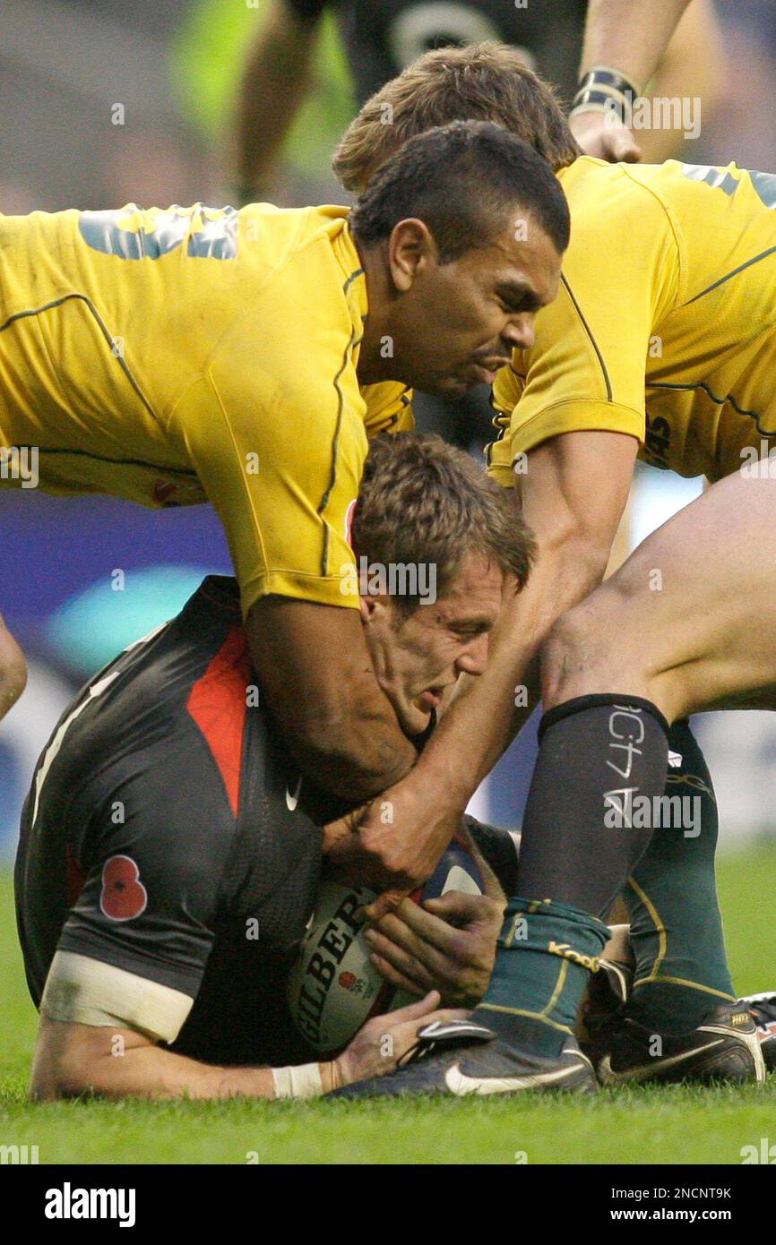 England's Mark Cueto, center lower, is tackled by Australia's Kurtley ...