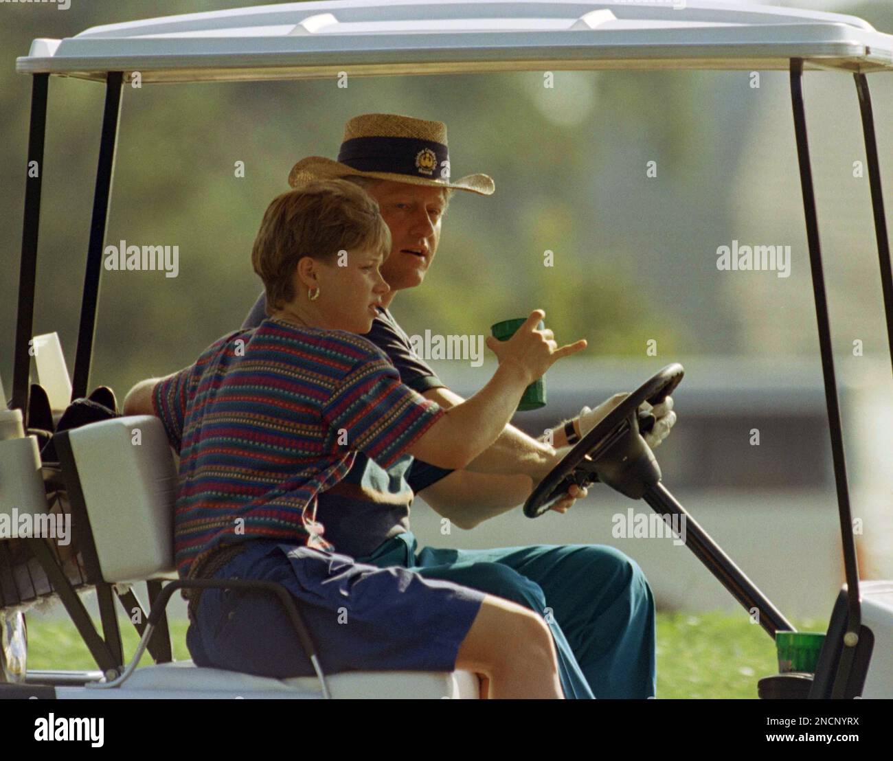 President Bill Clinton and his cousin, Lisa Cornwell, sit in a golf ...