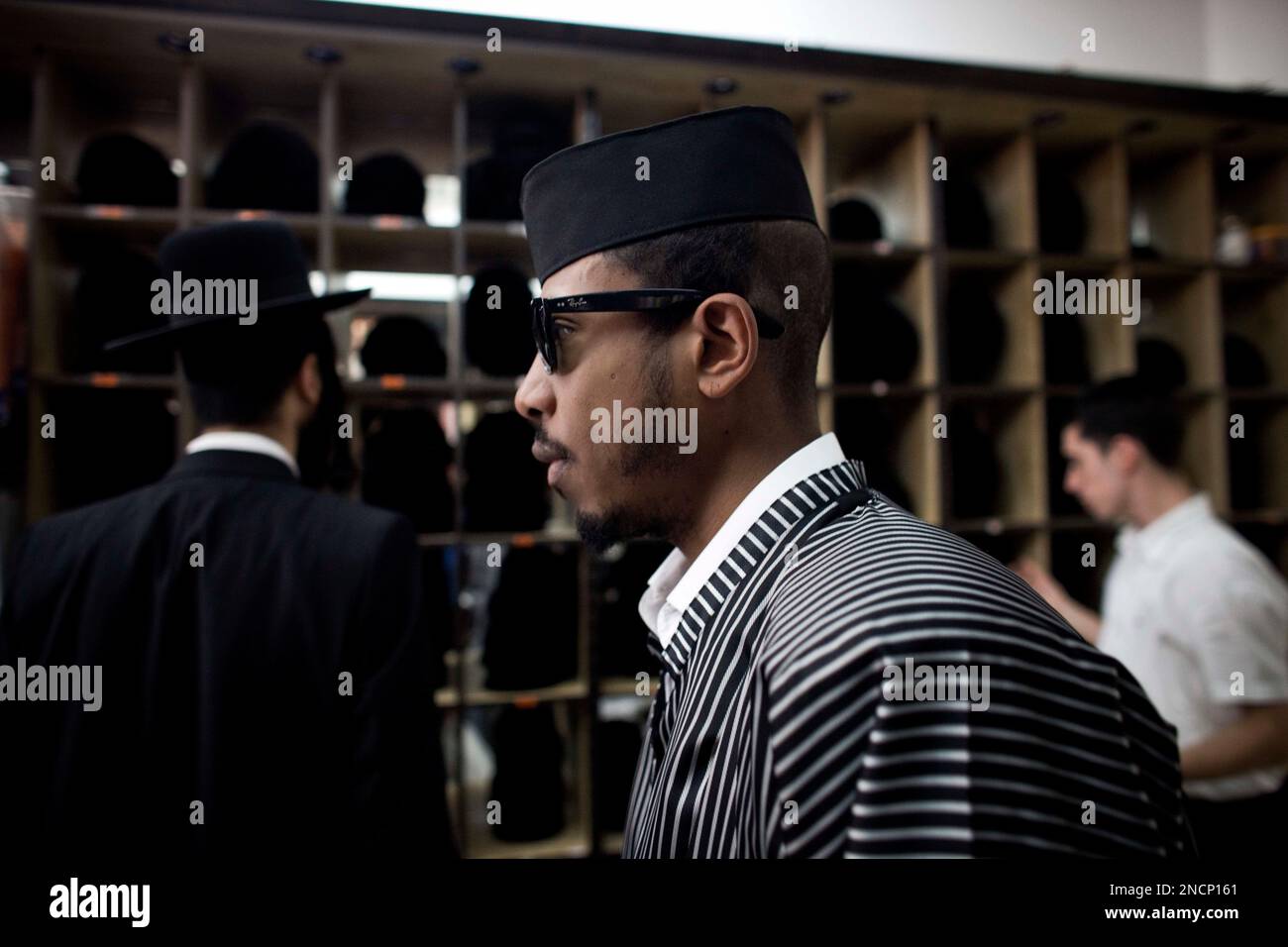 U.S. rapper Jamal "Shyne" Barrow, center, walks through a hat shop in ...