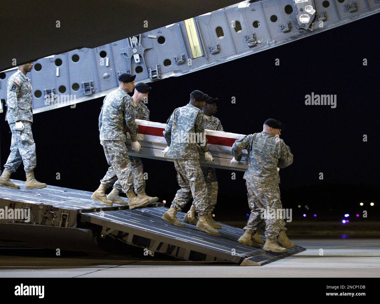 An Army carry team carries the transfer case containing the remains of ...