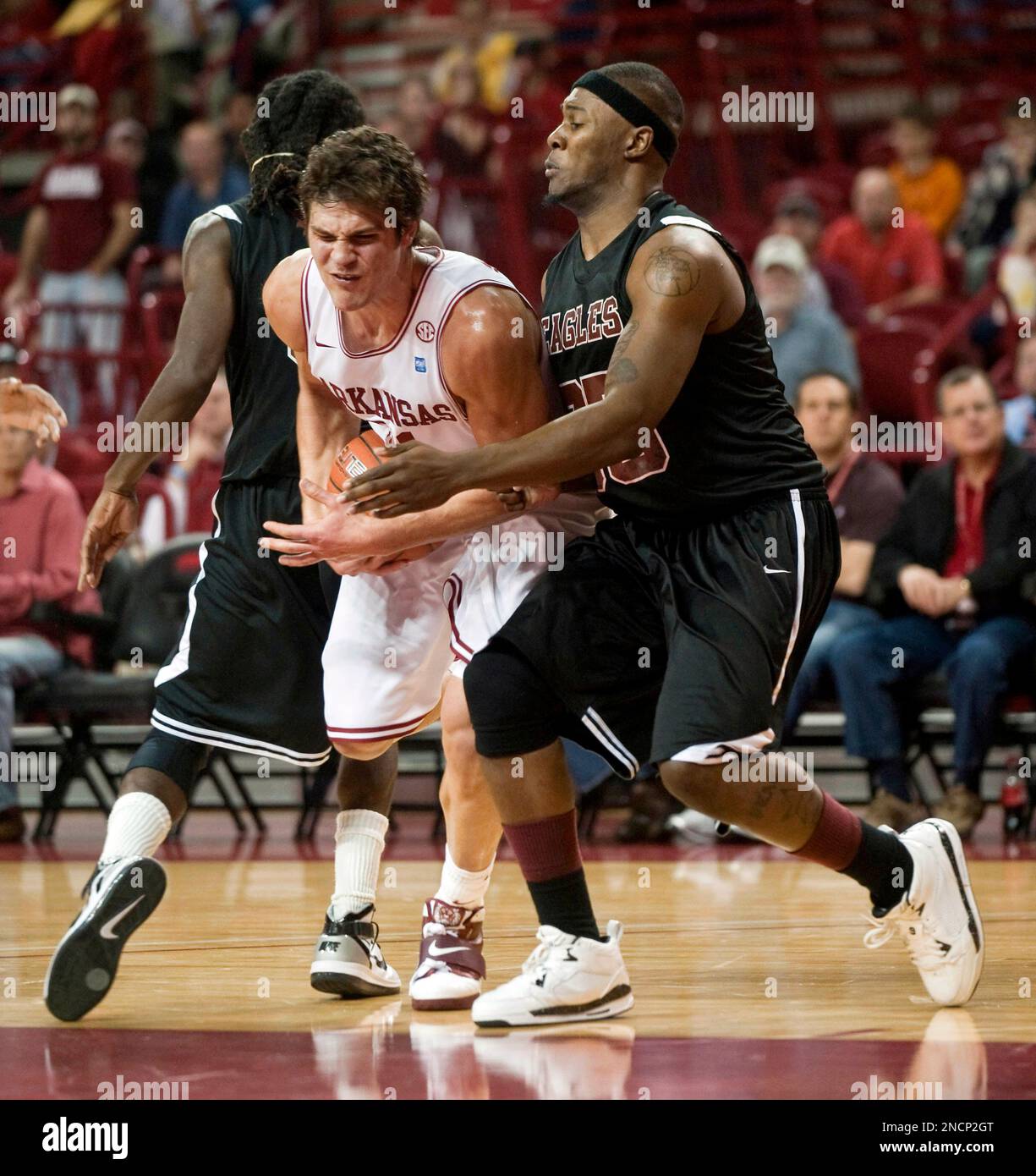 Arkansas' Michael Sanchez, center, charges past Victory's Jeremy Carr ...