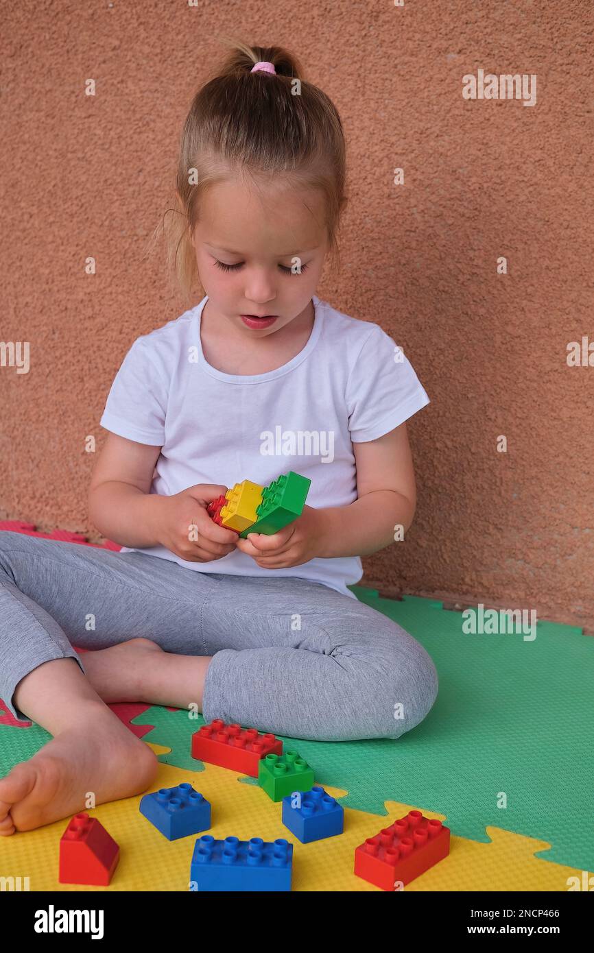 cute little girl playing building blocks lego colorful constructor ...