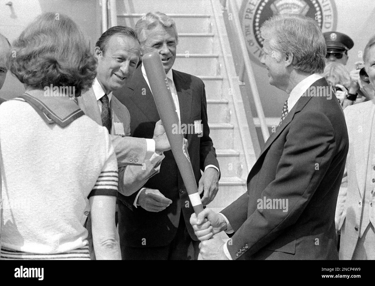 U.S. President Jimmy Carter takes instruction on how to grip a baseball ...