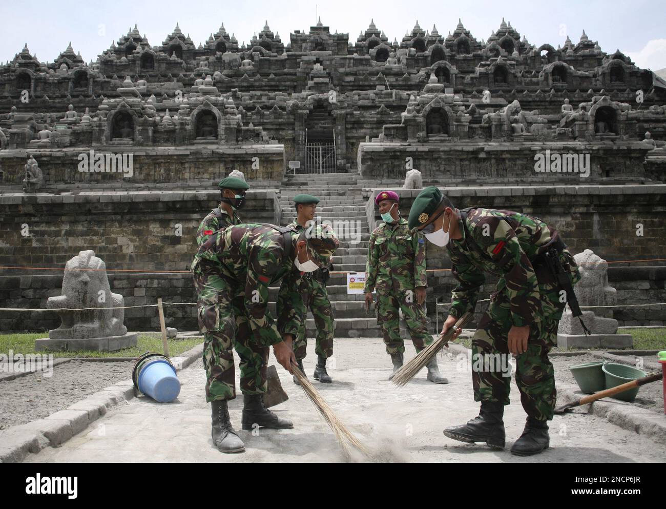 Indonesian soldiers clean volcanic ash from the eruption of Mount ...