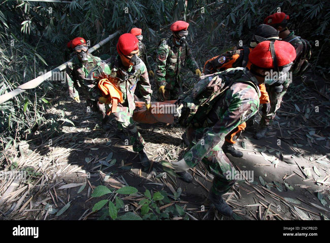 Indonesian army soldiers carry the remains of a victim killed by the ...