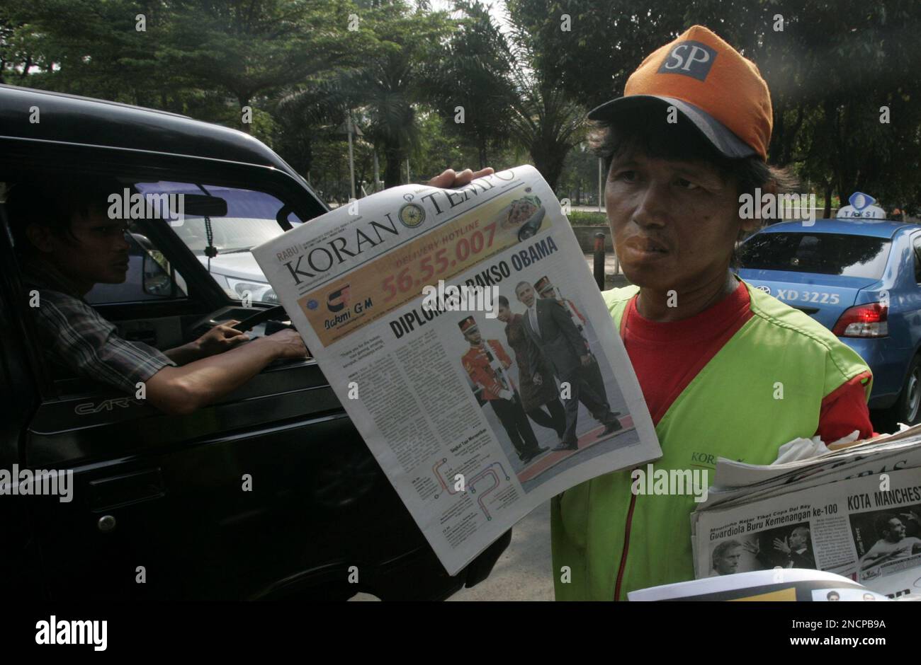 A street vendor holds newspapers in Jakarta, Indonesia, Wednesday, Nov ...
