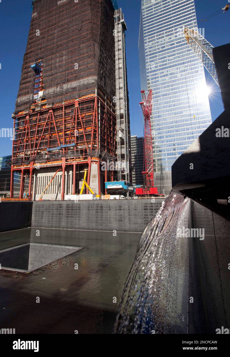 Streams of water pour over the edge of a National September 11 Memorial ...