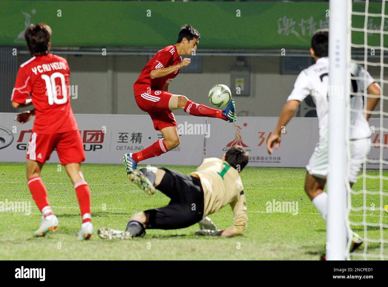 Hong Kong's Chan Wai Ho, center top, kicks the ball to score a goal ...