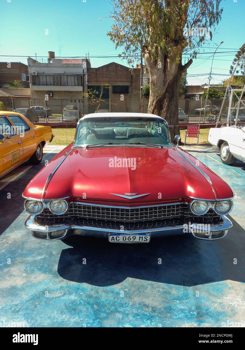 Old red luxury 1960 Cadillac coupe DeVille in a park. Sunny day. Front ...