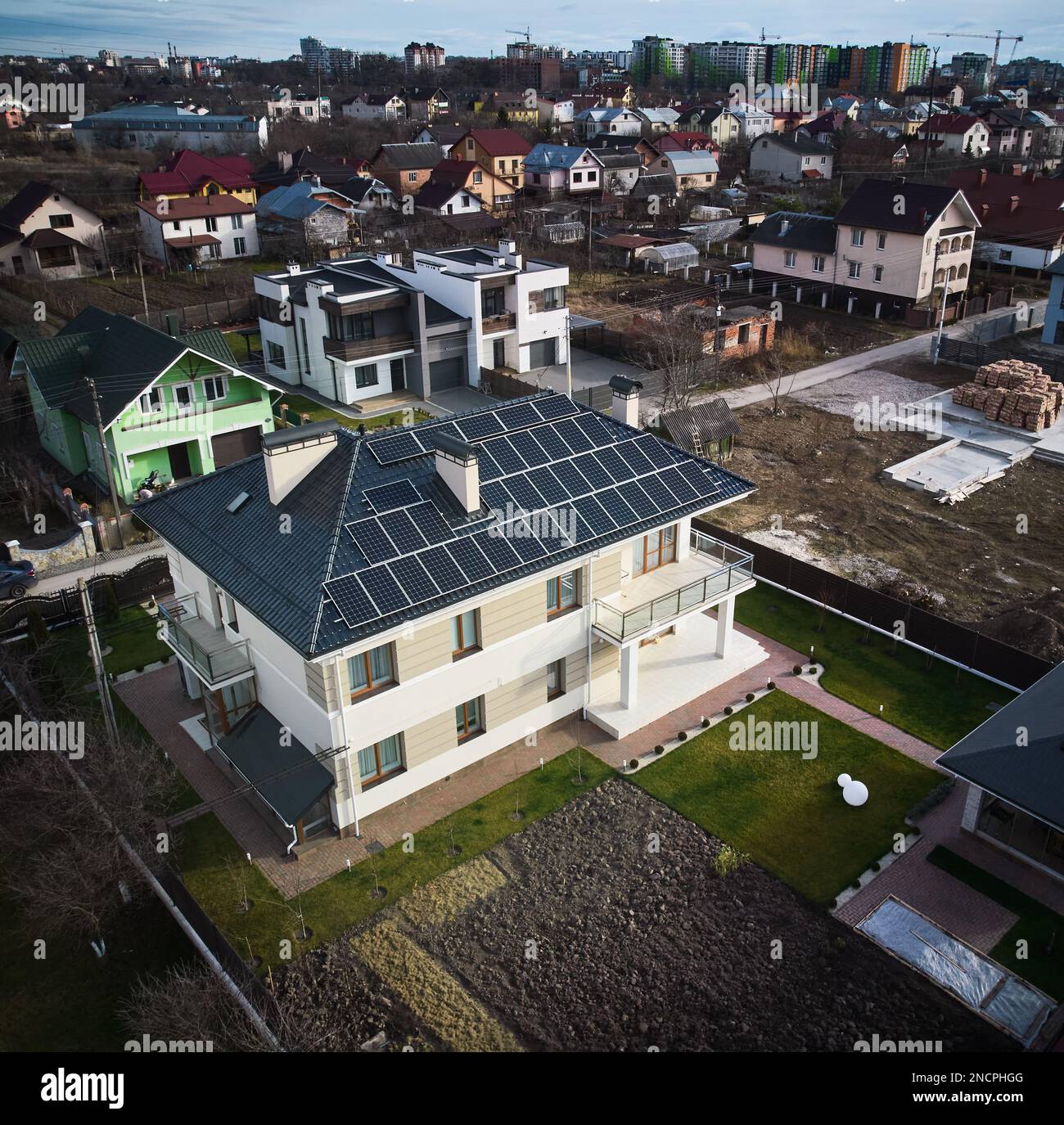 Aerial view of two-storey house with solar panel modules for generating ...
