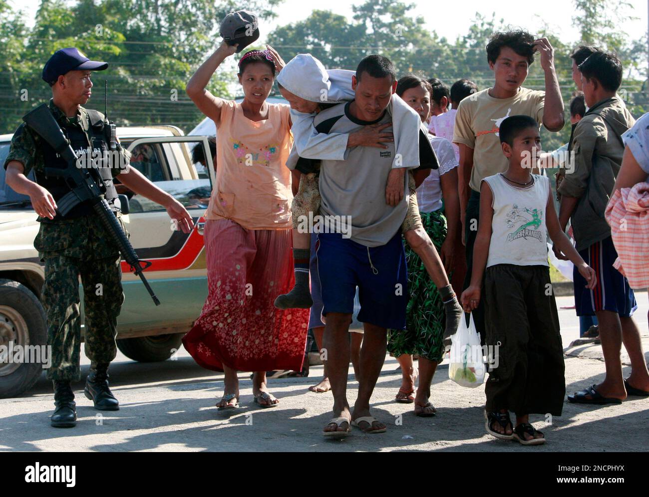A Thai soldier, left, looks at Myanmar citizens arriving at the Border ...